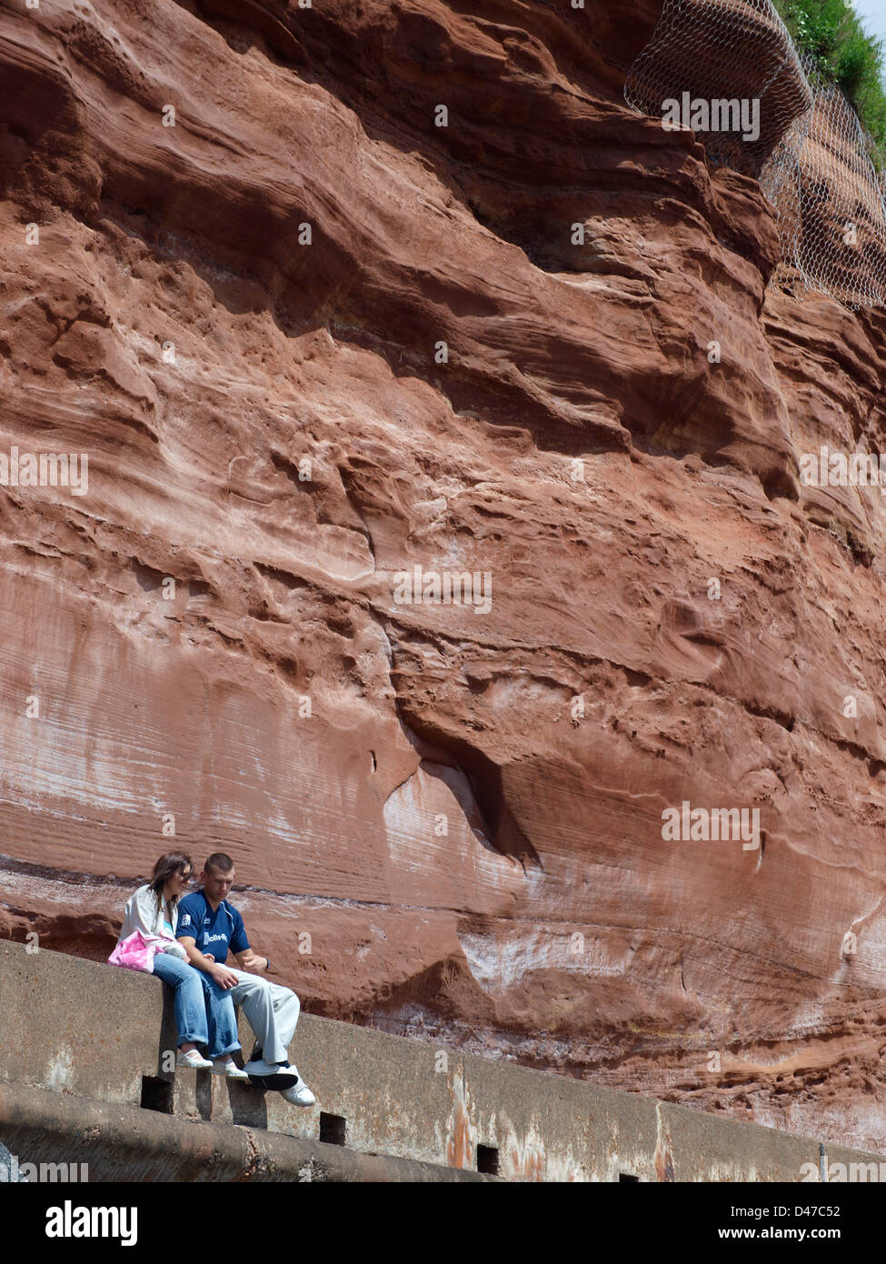 Red sandstone rock at Sidmouth with walkway underneath Stock Photo - Alamy