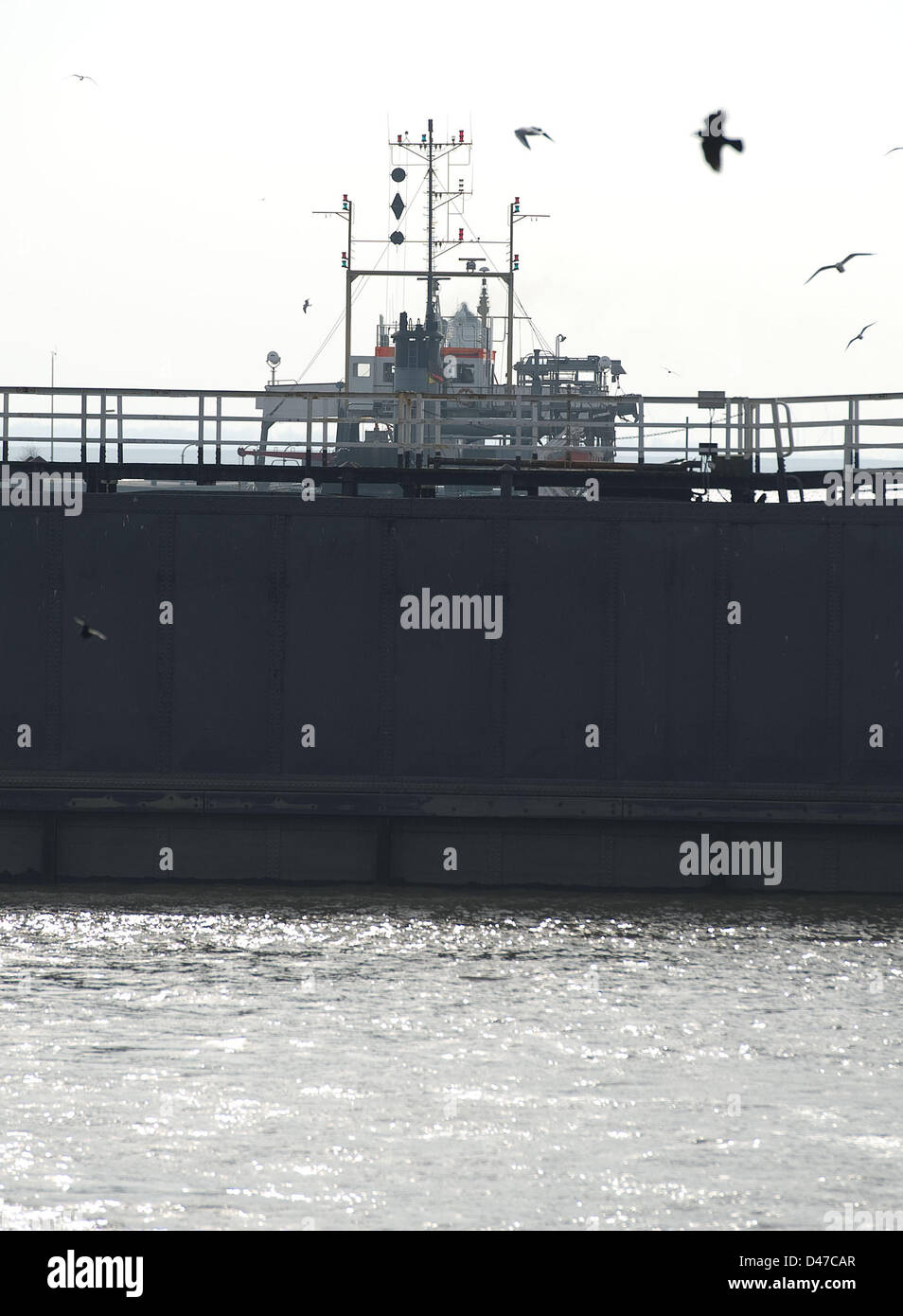 A freighter ship is docked in front of the lock gates at the Kiel Canal ...