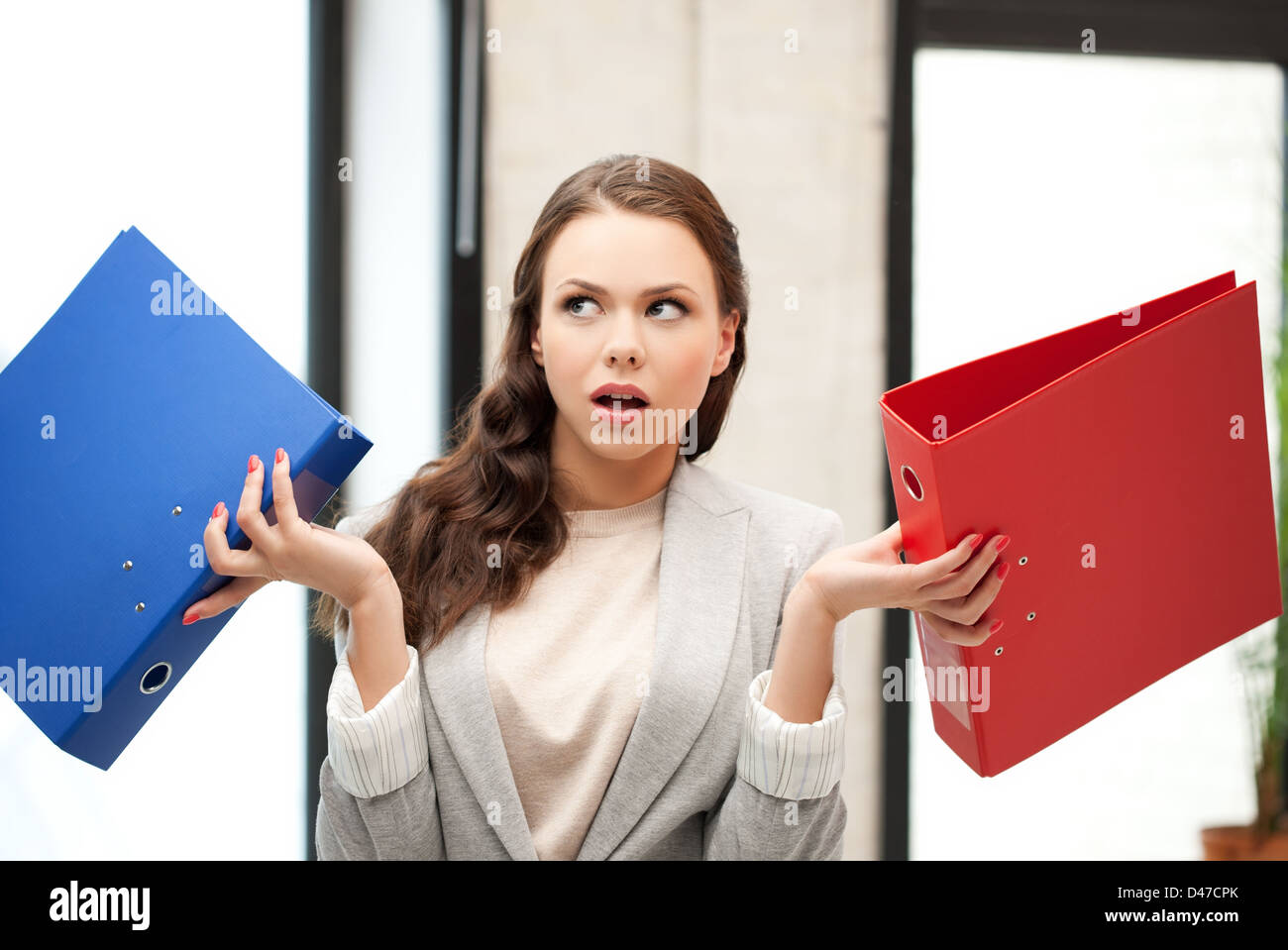 unsure thinking or wondering woman with folder Stock Photo - Alamy