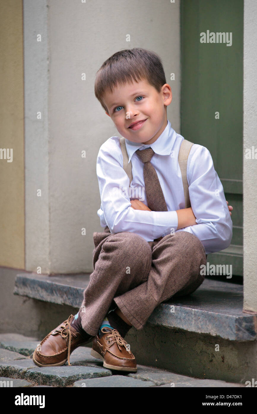 Portrait of a little boy sitting on the porch, facial expression series ...