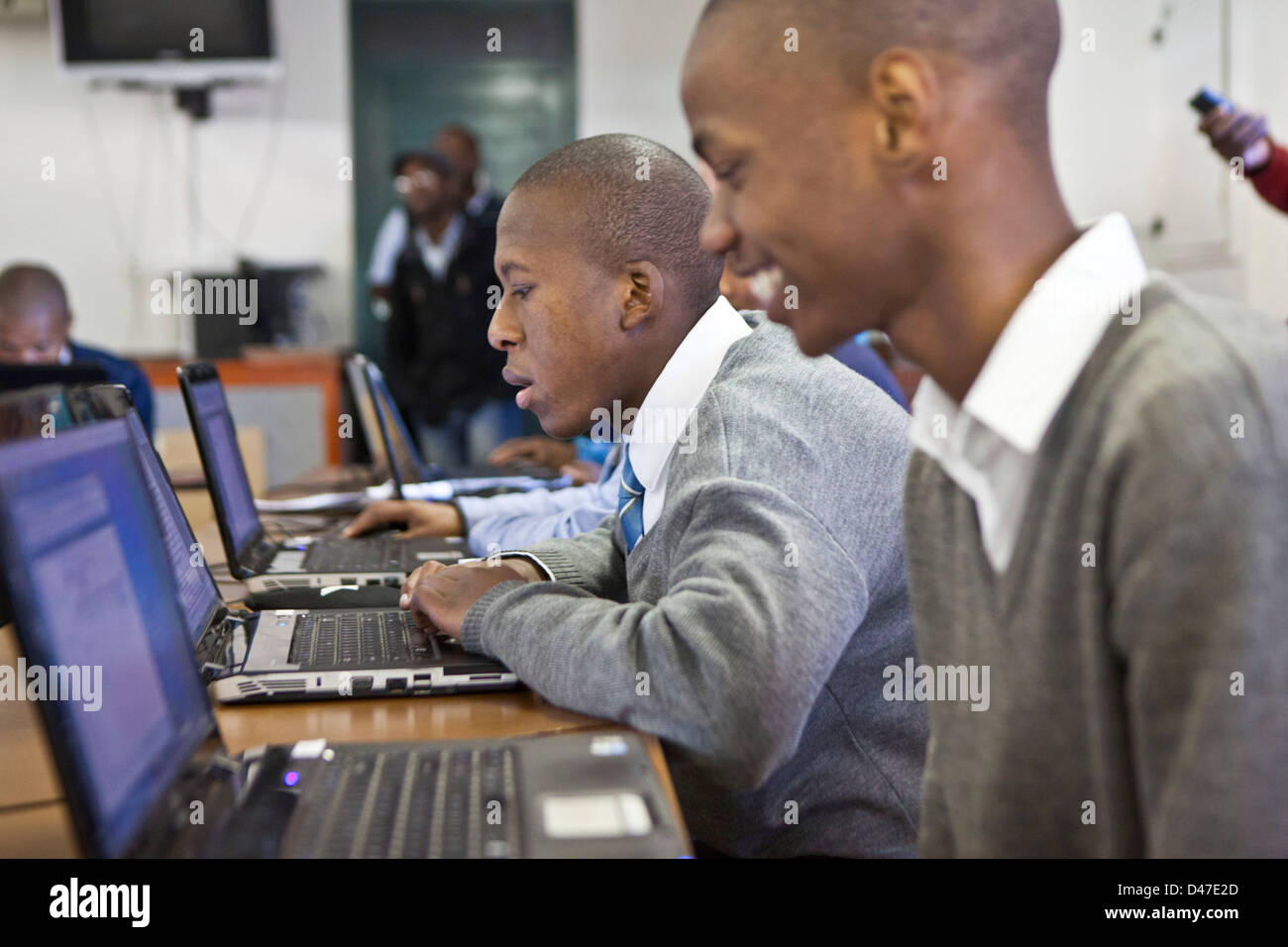A class of South African school children concentrate on laptops during ...