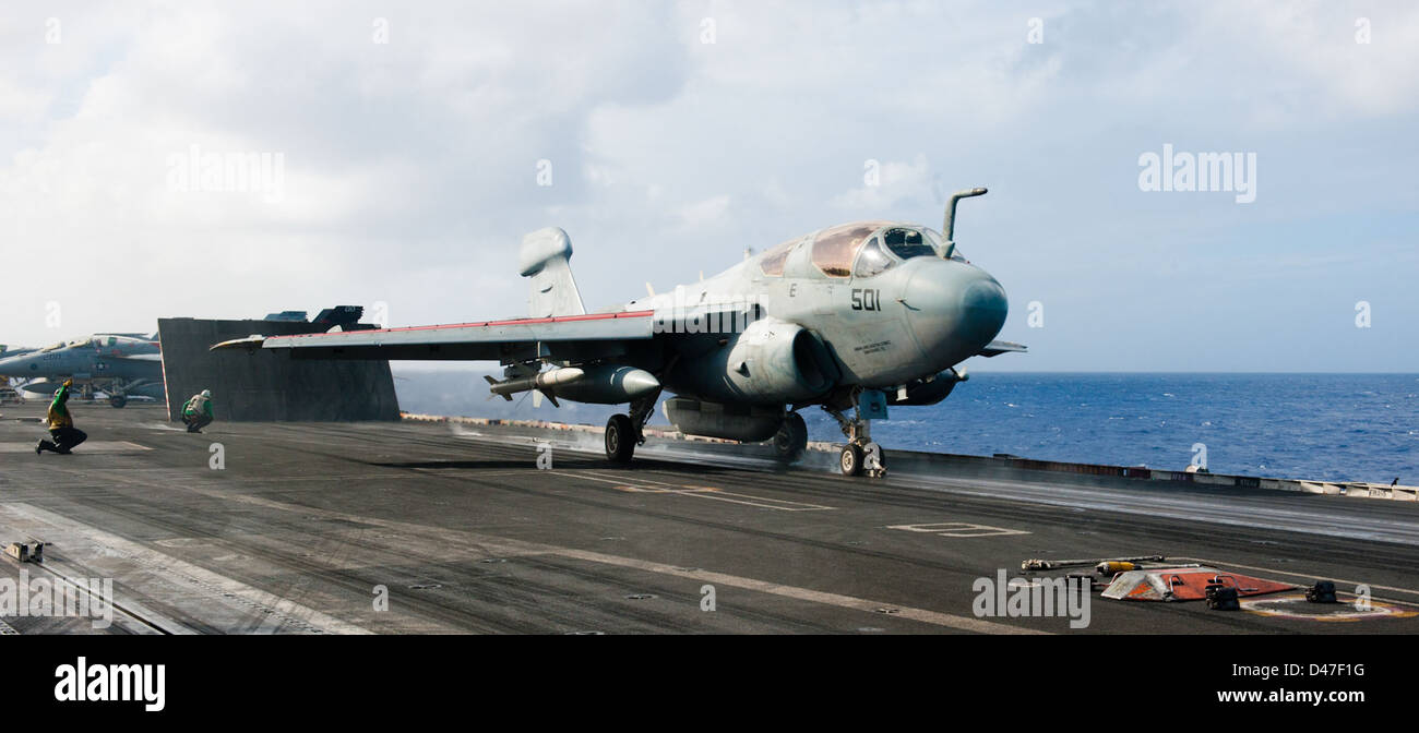 A U.S. Navy jet launches from the flight deck of an aircraft carrier in ...