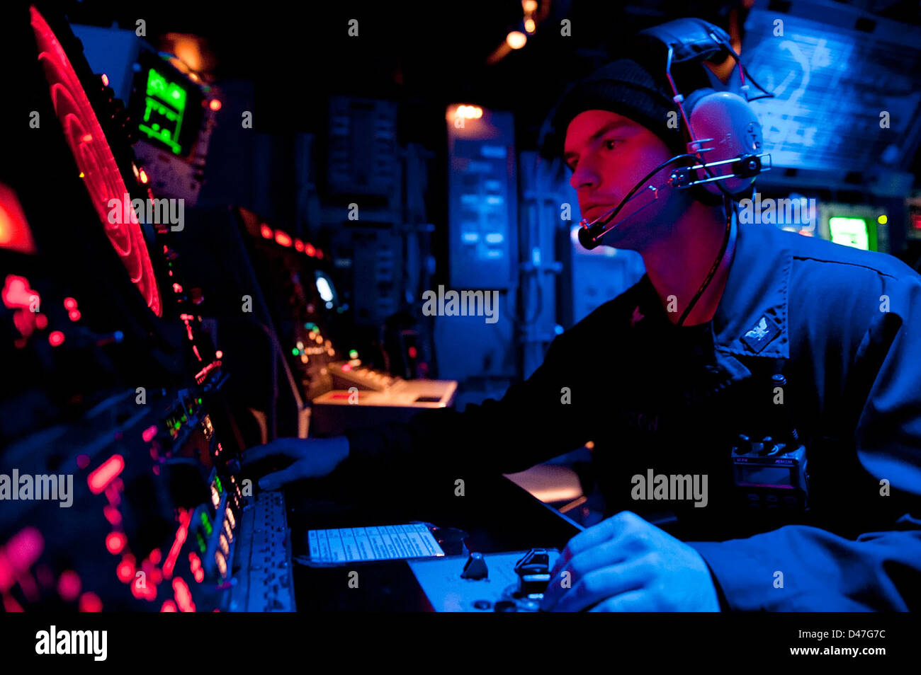 A Sailor stands watch in the Combat Information Center (CIC) aboard a U ...