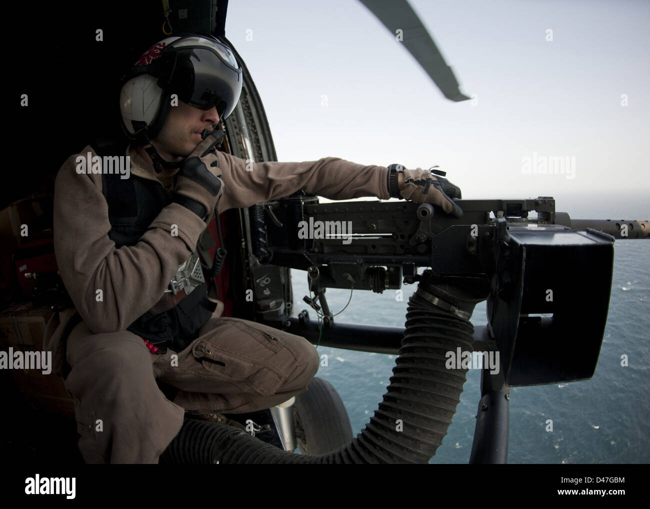 Naval Air Crewman Airman Terry Warren operates a .50 caliber machine ...