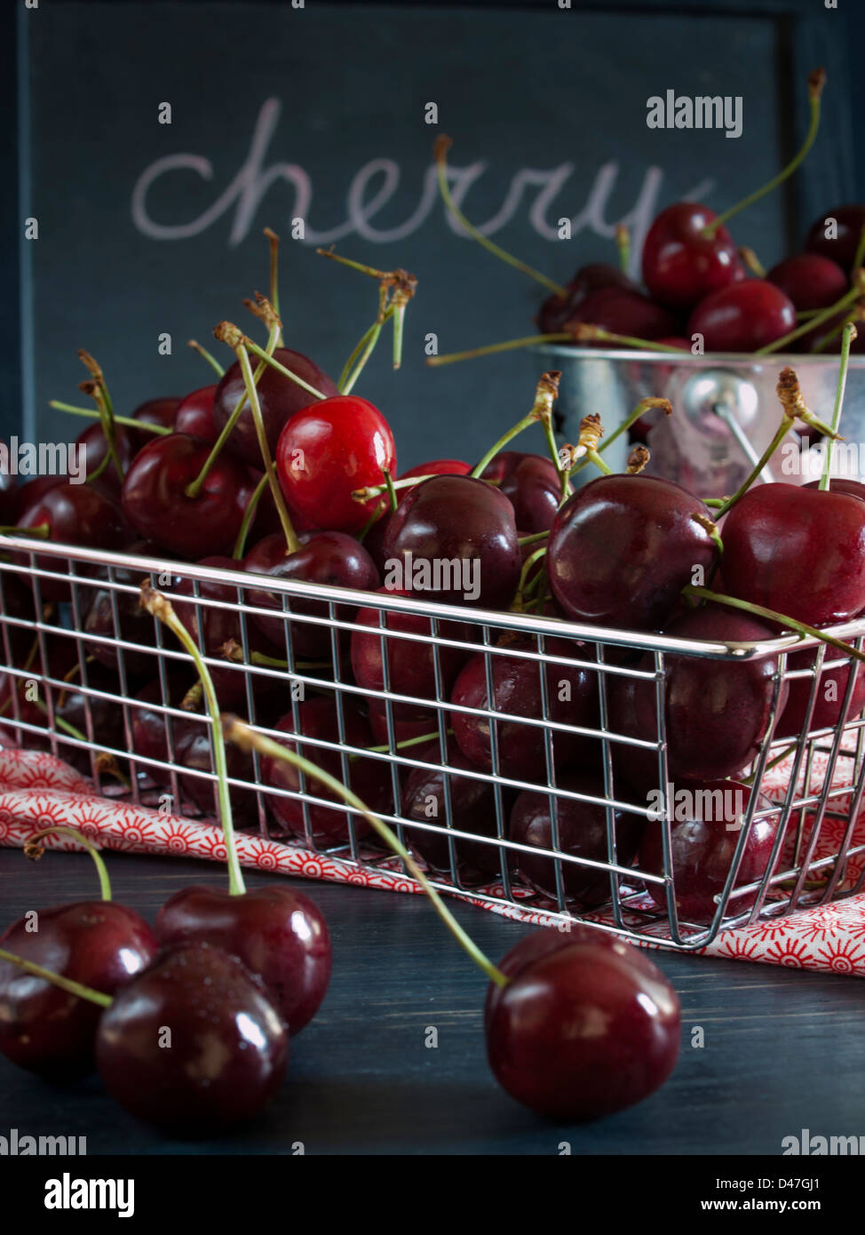 Freshly picked heap of cherries in metal basket Stock Photo - Alamy