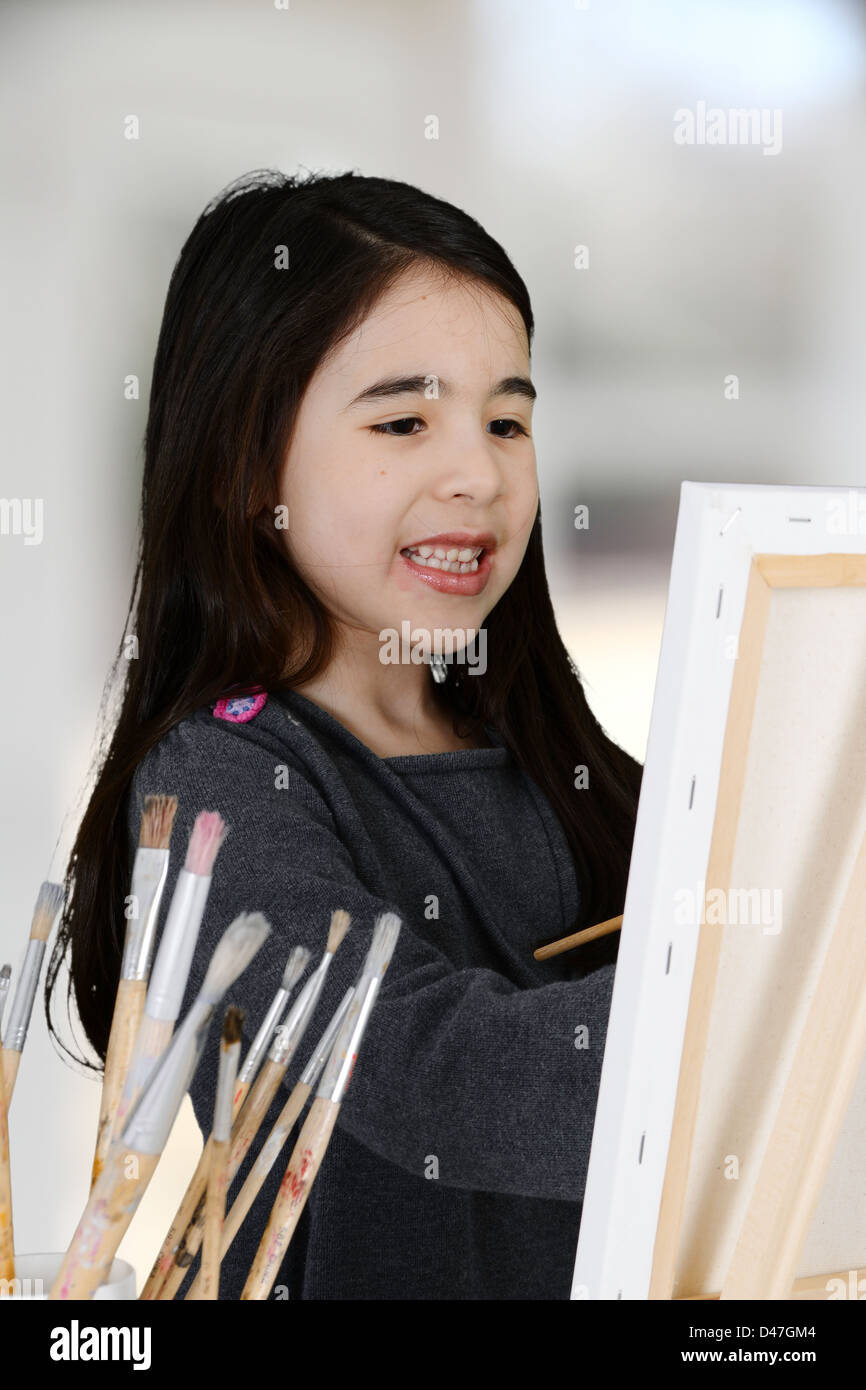 Girl painting a canvas while at school Stock Photo - Alamy