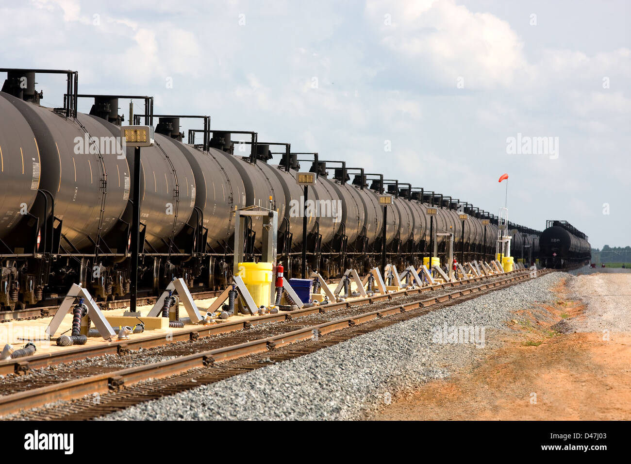 Long lines of railroad oil tanker cars stretch off into the distance ...