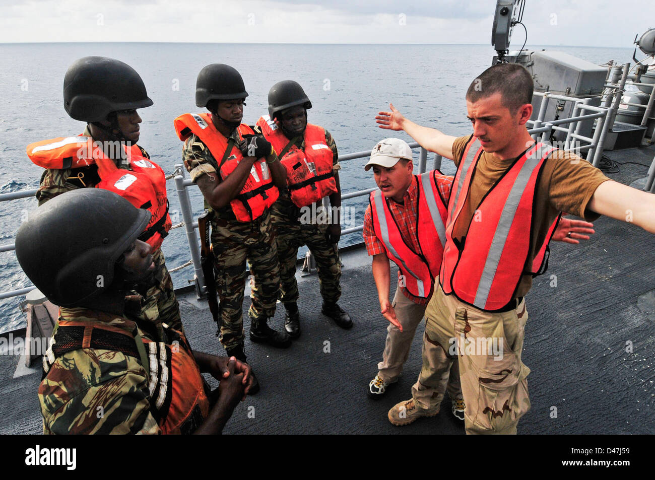 A U.S. Navy Sailor demonstrates proper procedures for searching a ...