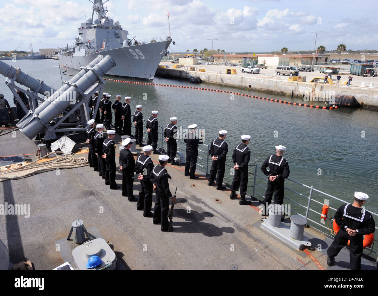 Sailors aboard the USS Vicksburg (CG 69) stand at attention on the ...