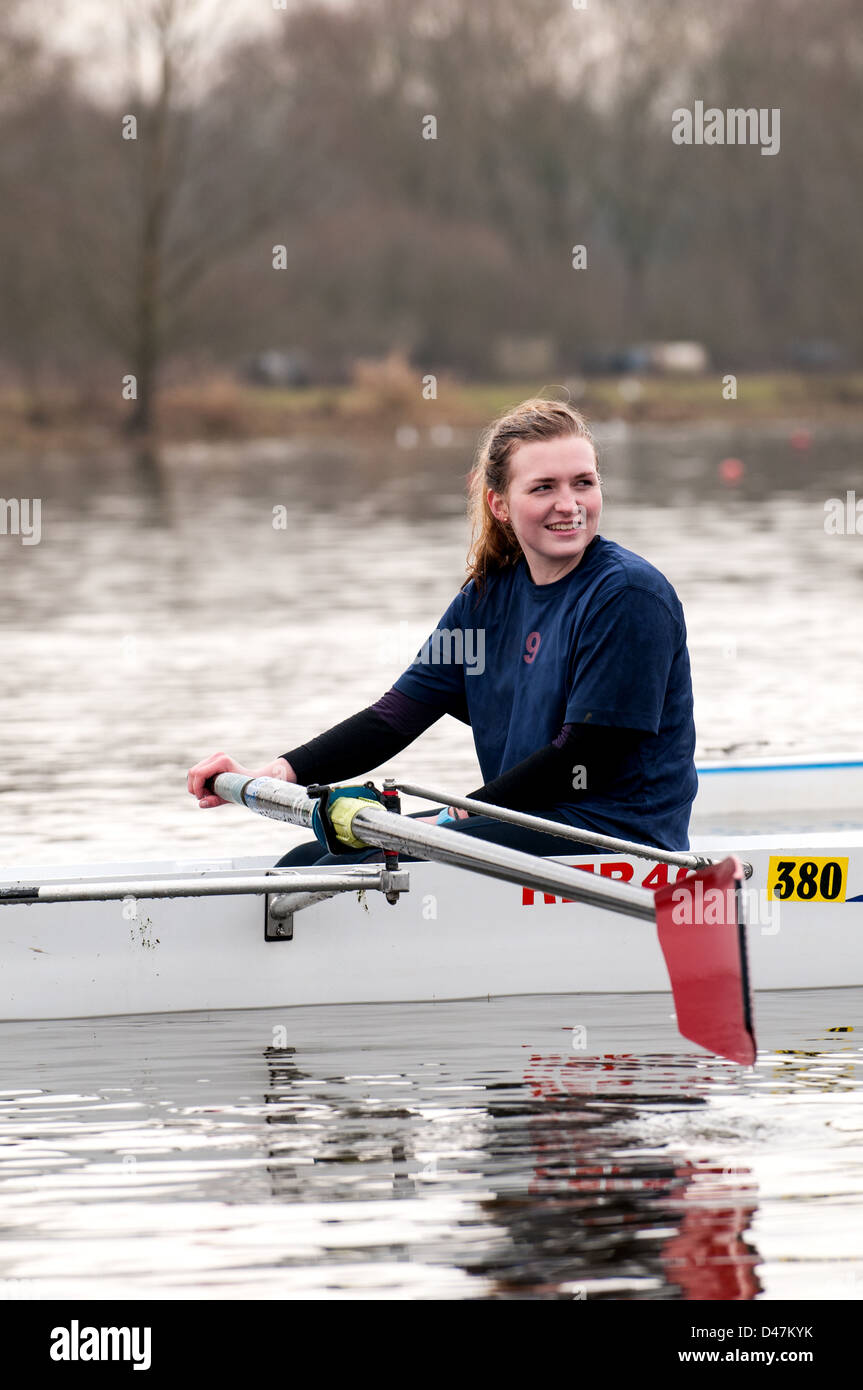 Young woman sitting relaxed in a rowing boat during a training session ...