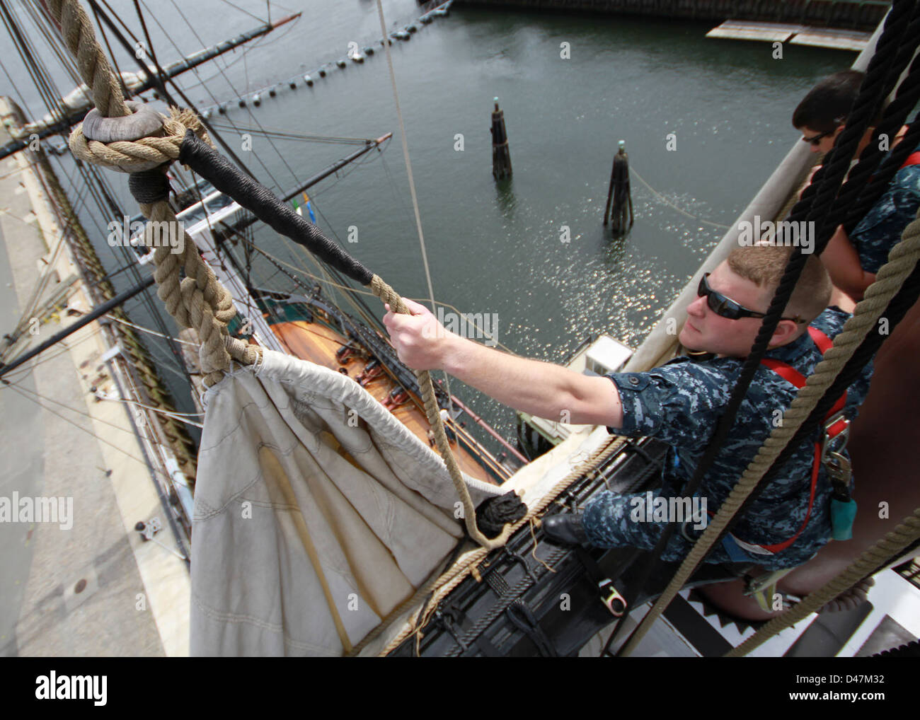 A Sailor aboard the USS Constitution adjusts the topsail on the main ...