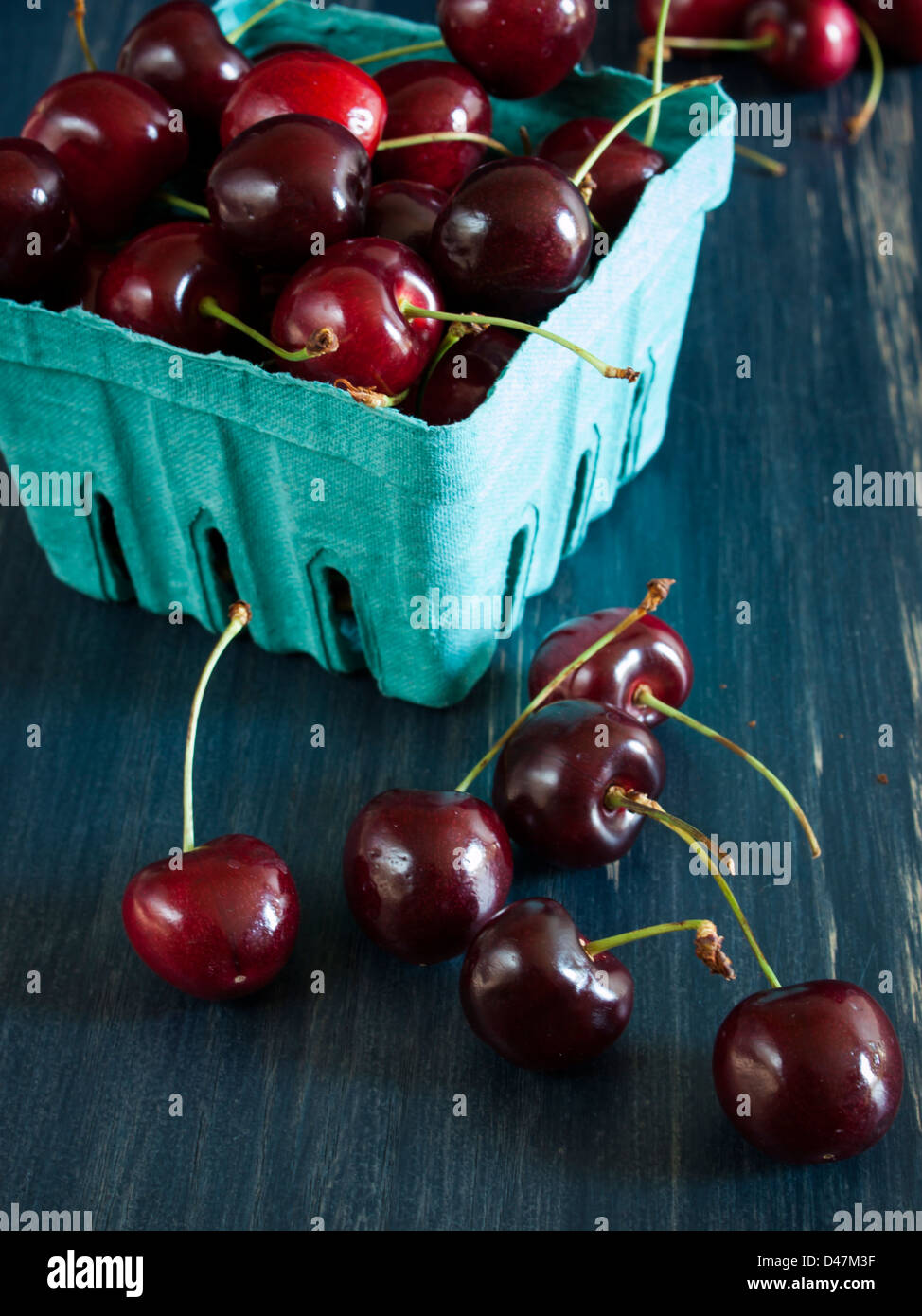 Freshly picked heap of cherries in blue basket Stock Photo - Alamy