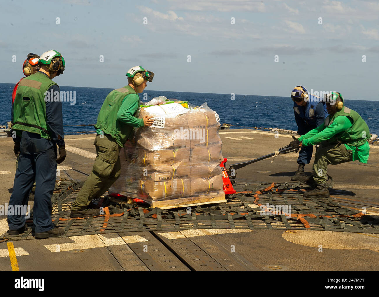 Sailors aboard USS Taylor move stores during a replenishment at sea ...