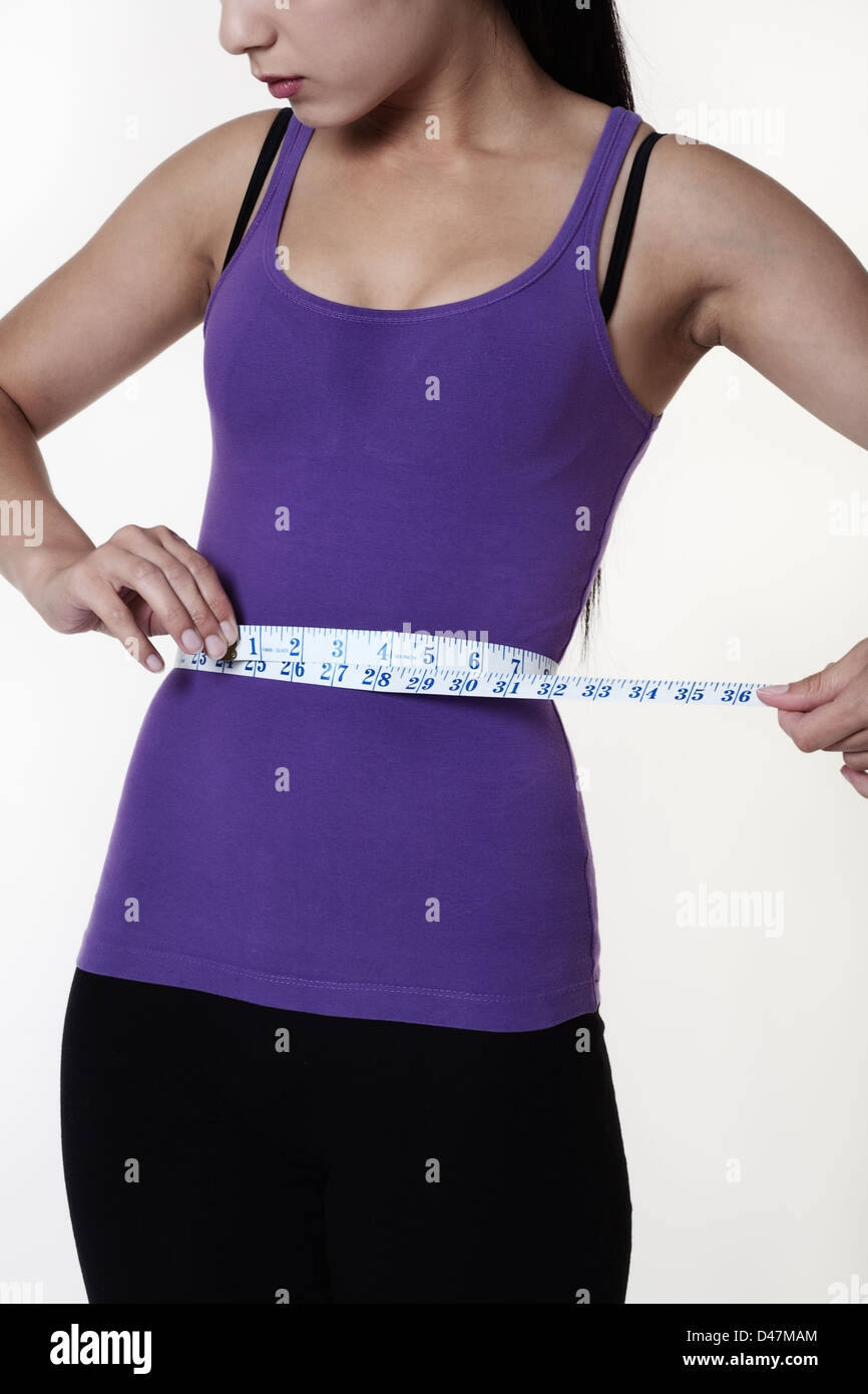 Closeup of tape measure around woman waist Stock Photo - Alamy