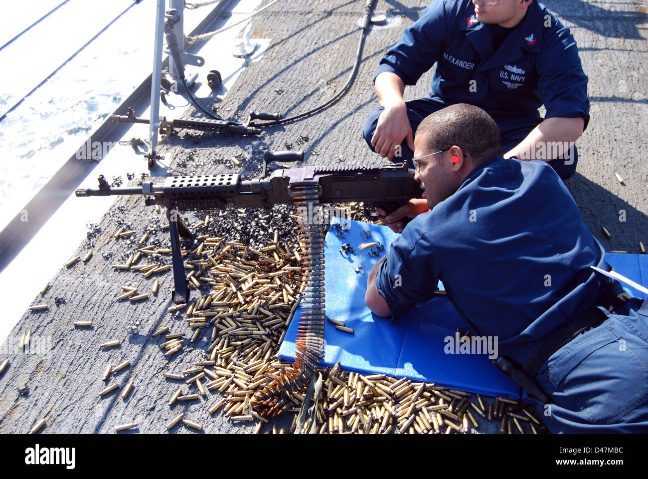 Gunner's Mate Seaman Deandre Bell operates an M240B machine gun aboard ...