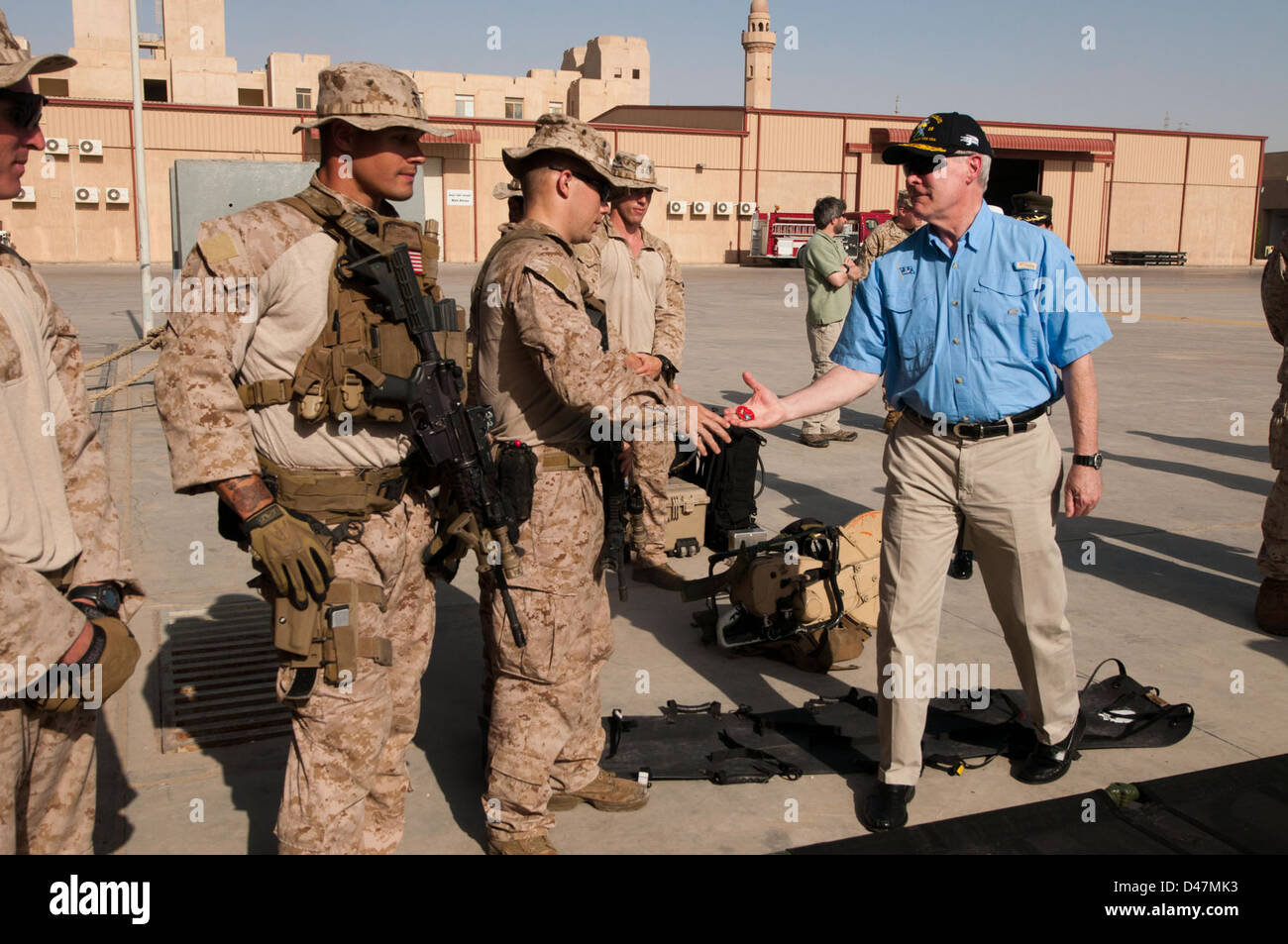 The Secretary of the Navy (SECNAV) presents a challenge coin to a ...