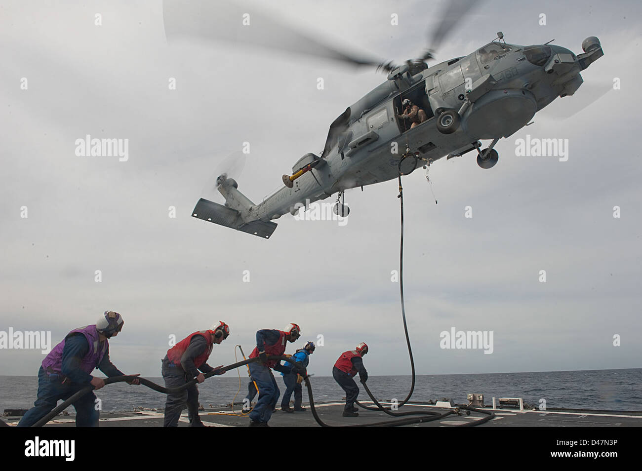 Sailors aboard a U.S. Navy vessel simulate refueling a helicopter ...