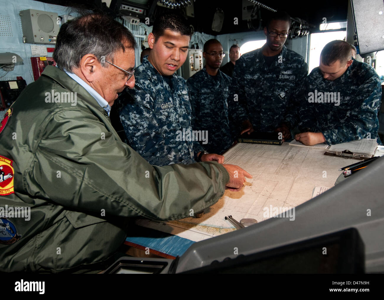 The U.S. Secretary of Defense examines navigation charts with the ...