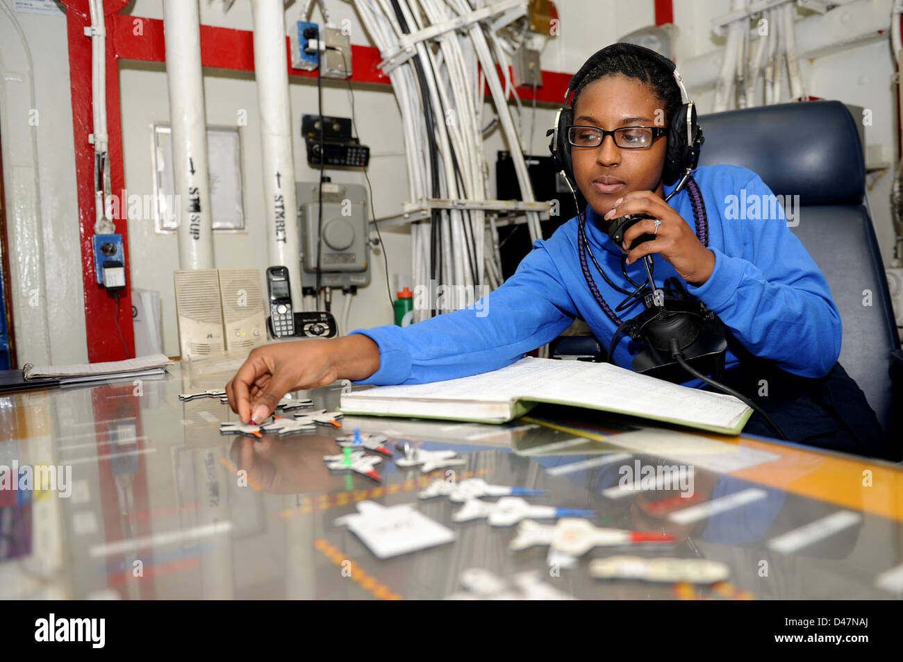 A Sailor reports aircraft status and updates in hangar deck control ...