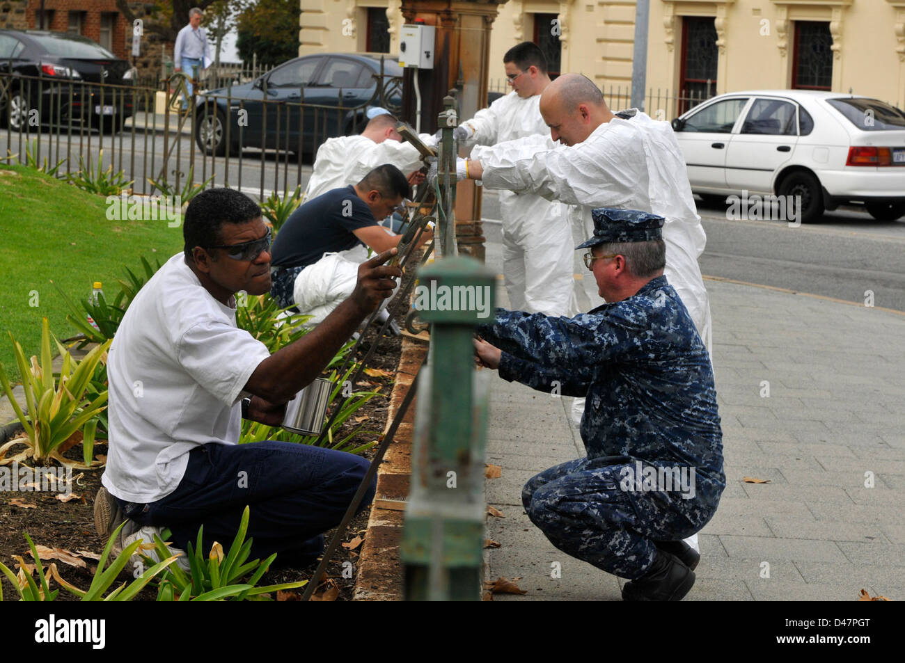 U.S. Navy sailors participate in a community service project, assisting ...