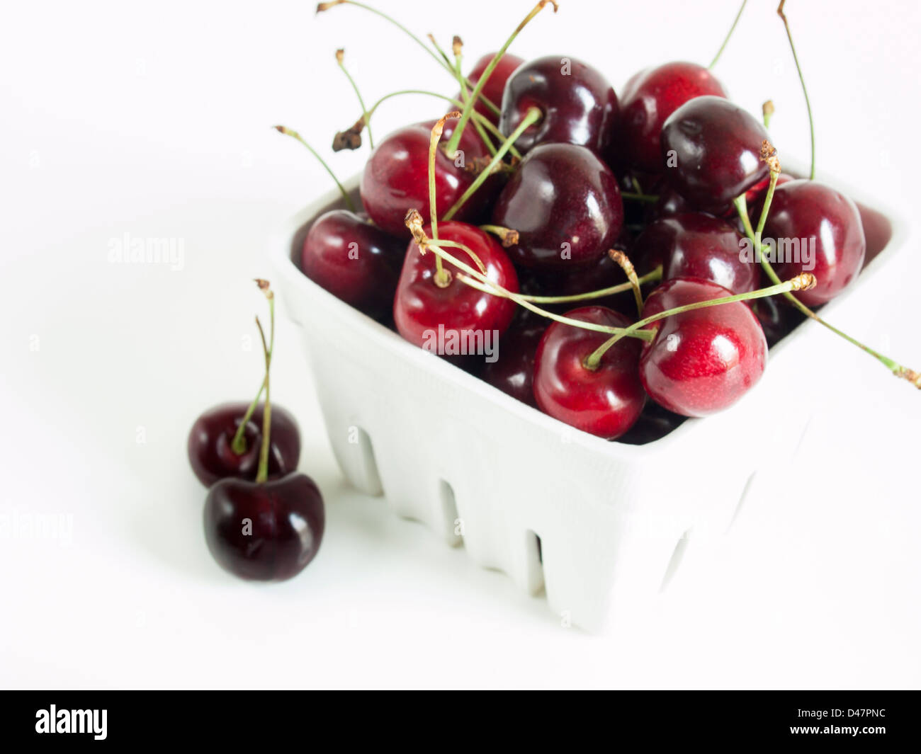 Freshly picked heap of cherries in white basket Stock Photo - Alamy