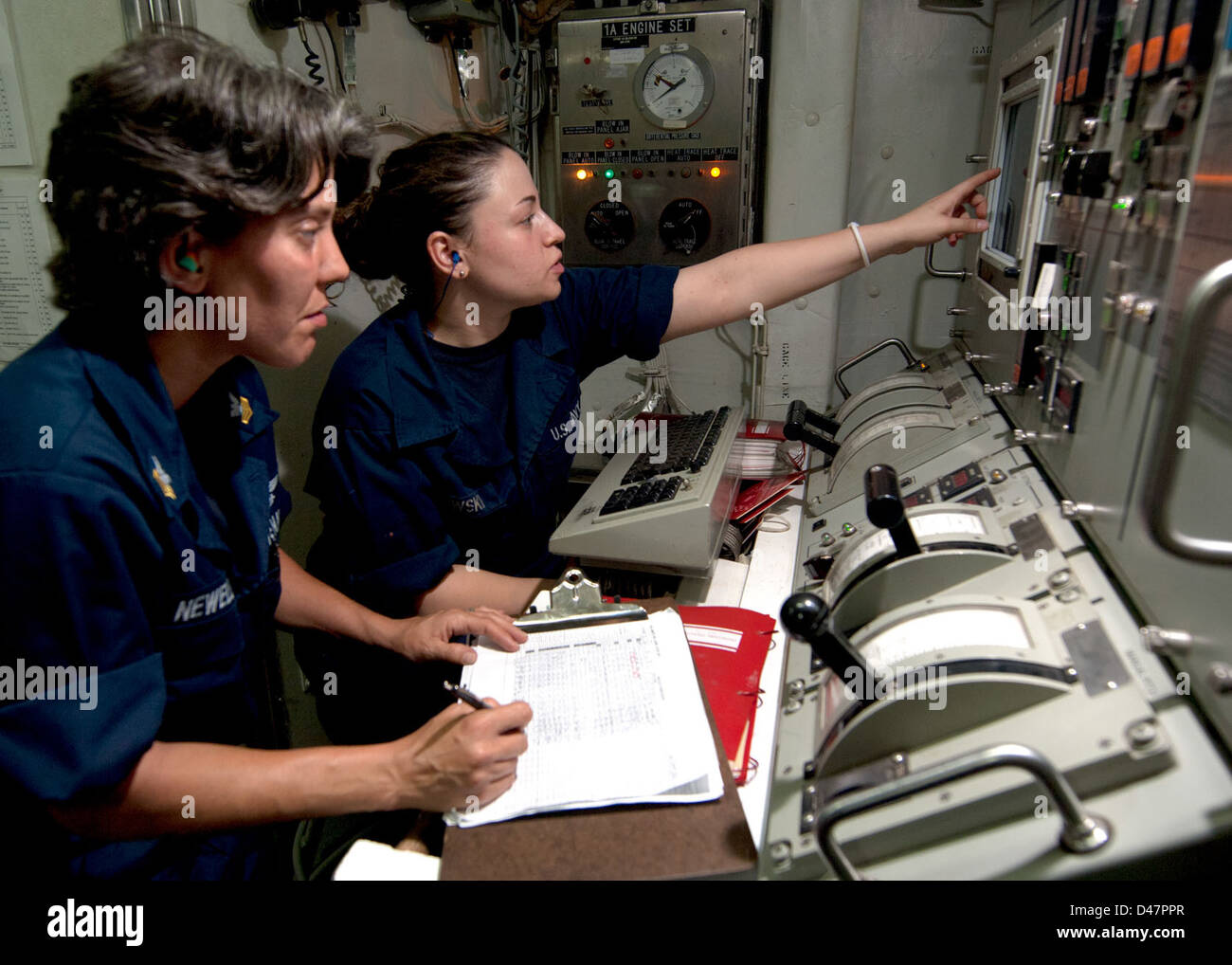 A sailor transcribes readings from a shaft control unit aboard the USS ...