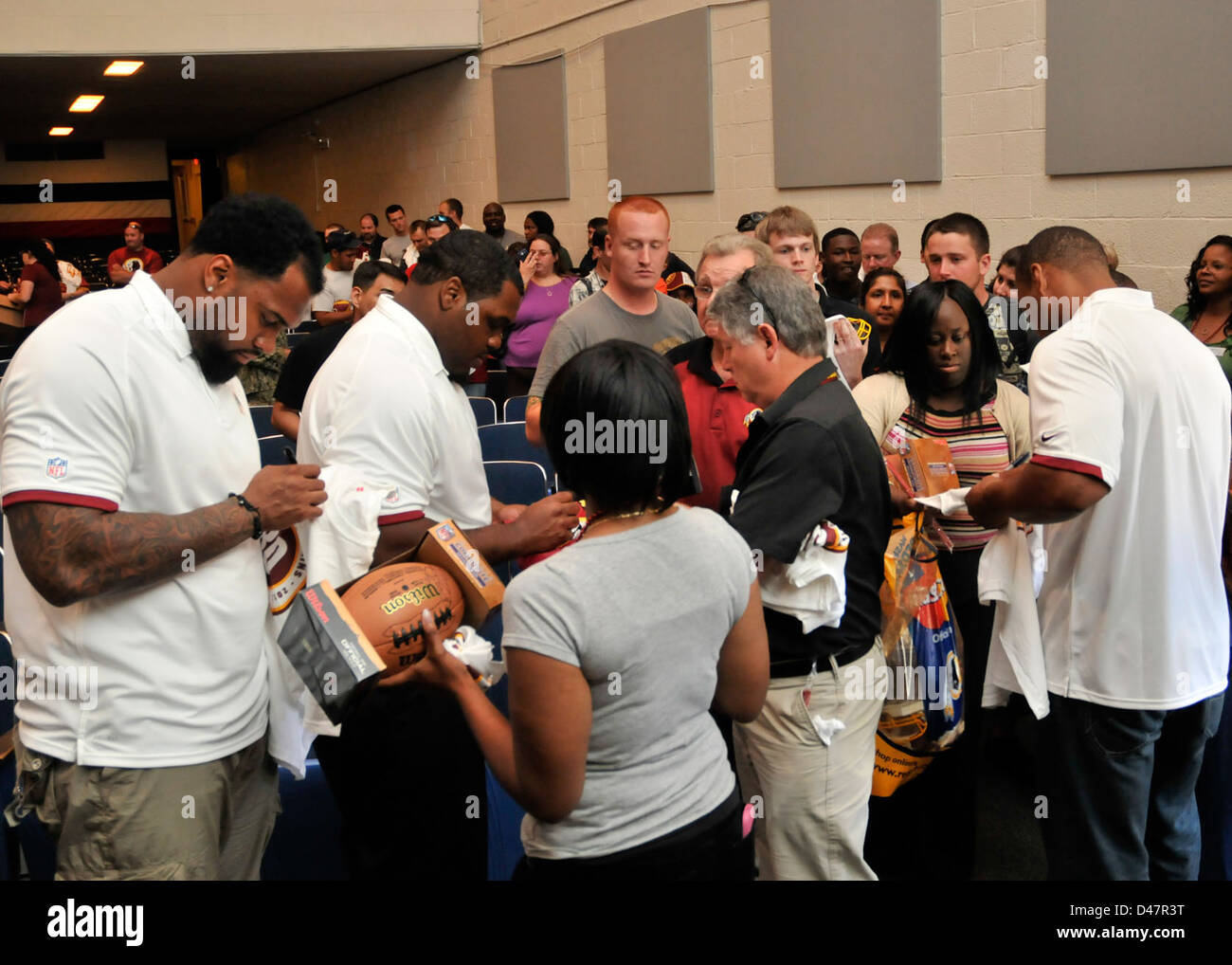 Players from the Washington Redskins sign autographs for fans during ...