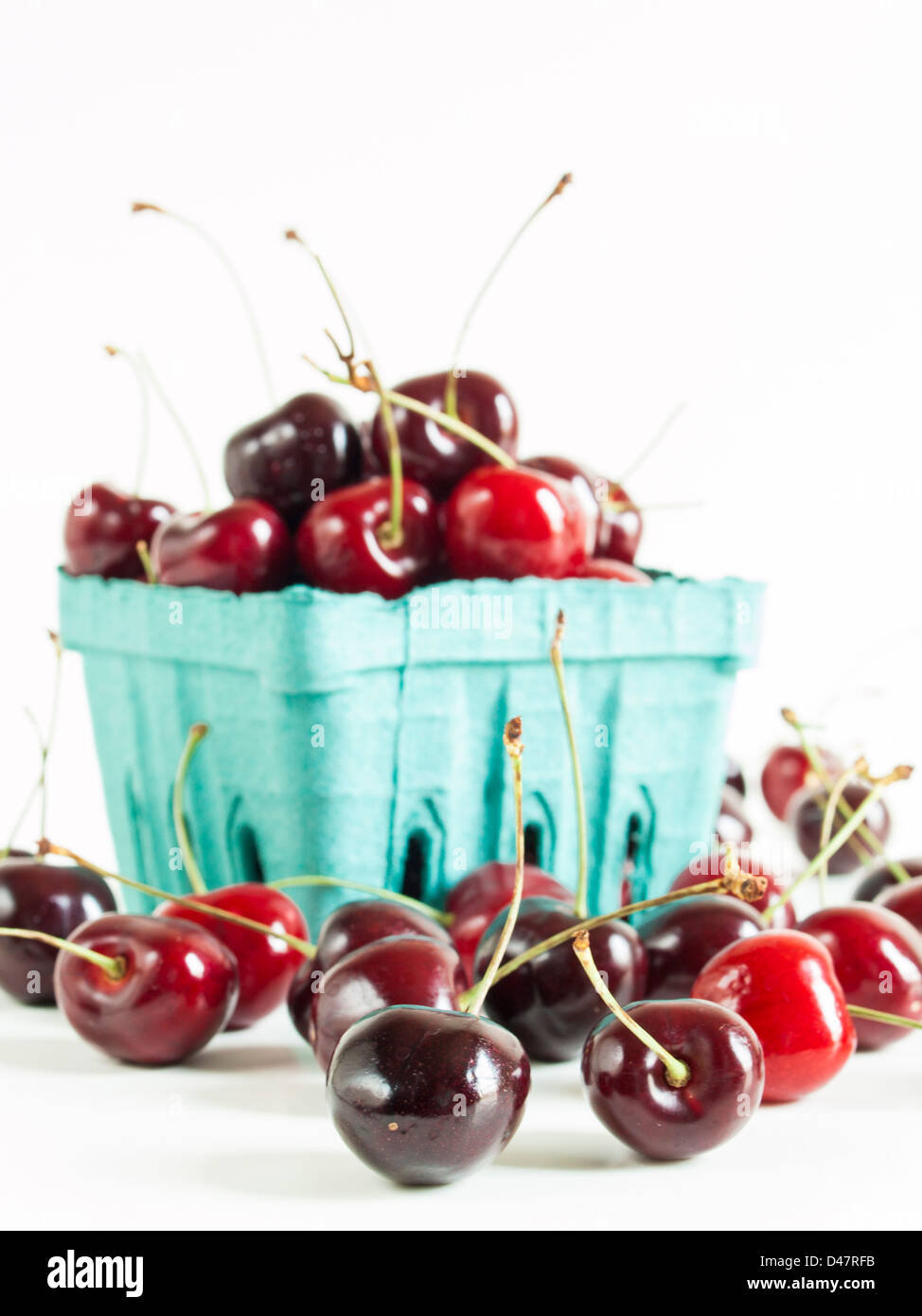 Freshly picked heap of cherries in blue basket Stock Photo - Alamy