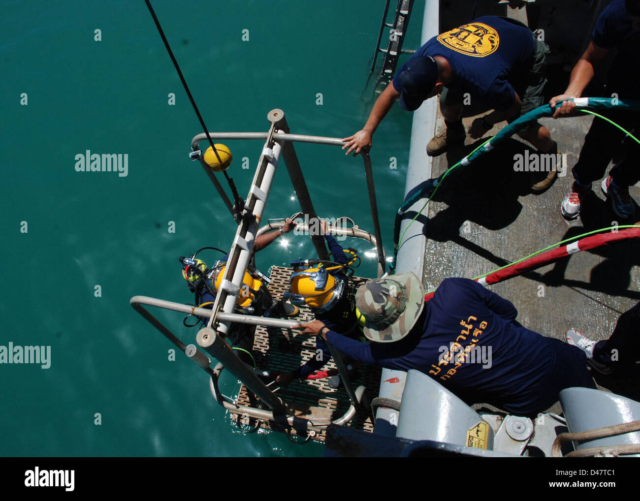 U.S. Navy and Royal Thai navy divers lower a Royal Thai Nnvy diver and ...