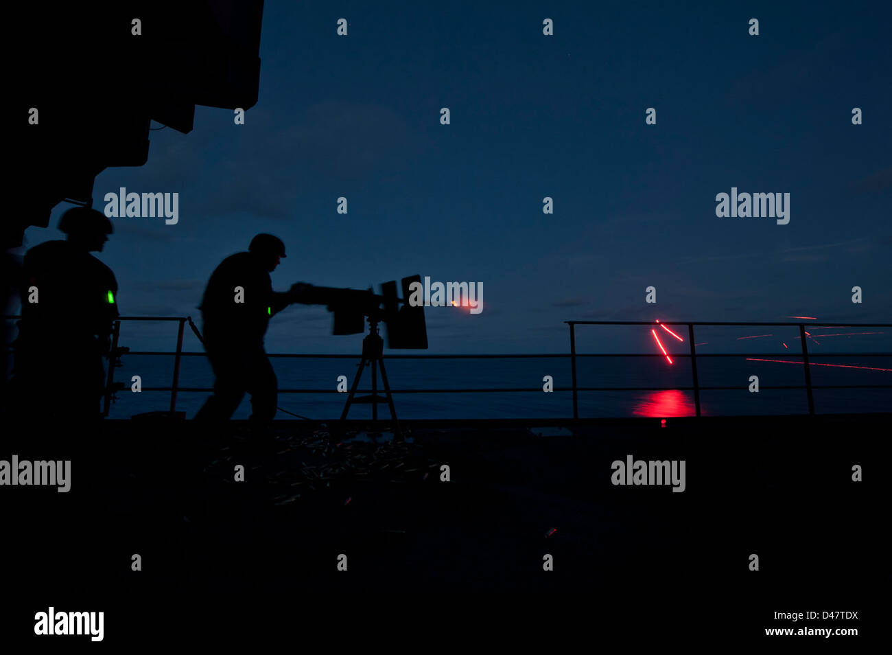 Weapons Department Sailors on a sponson fire a .50-caliber machine gun ...