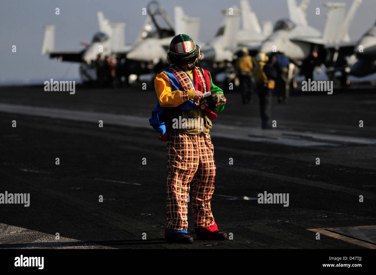 A Sailor aboard a U.S. Navy aircraft carrier wears a clown suit as part ...