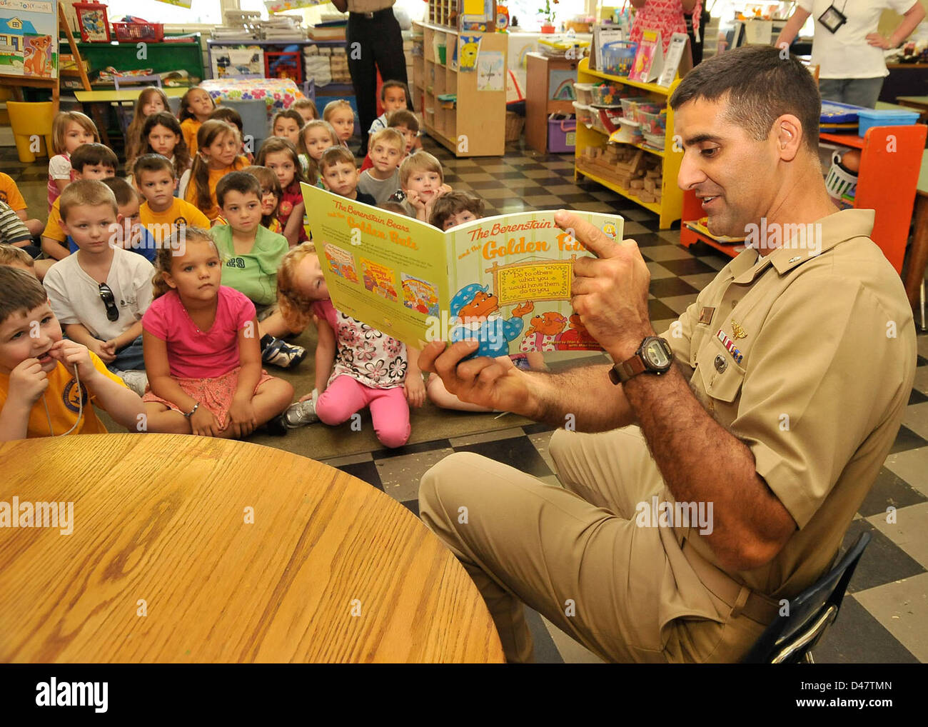 Cmdr. Mark J. Colombo of the USS Theodore Roosevelt reads to children ...