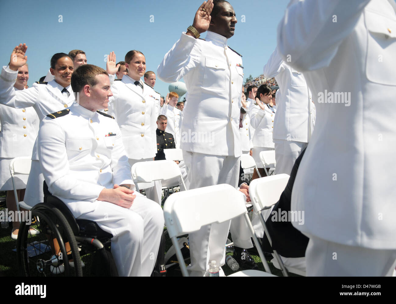 A Midshipmen 1st Class watches as his classmates take the oath of ...