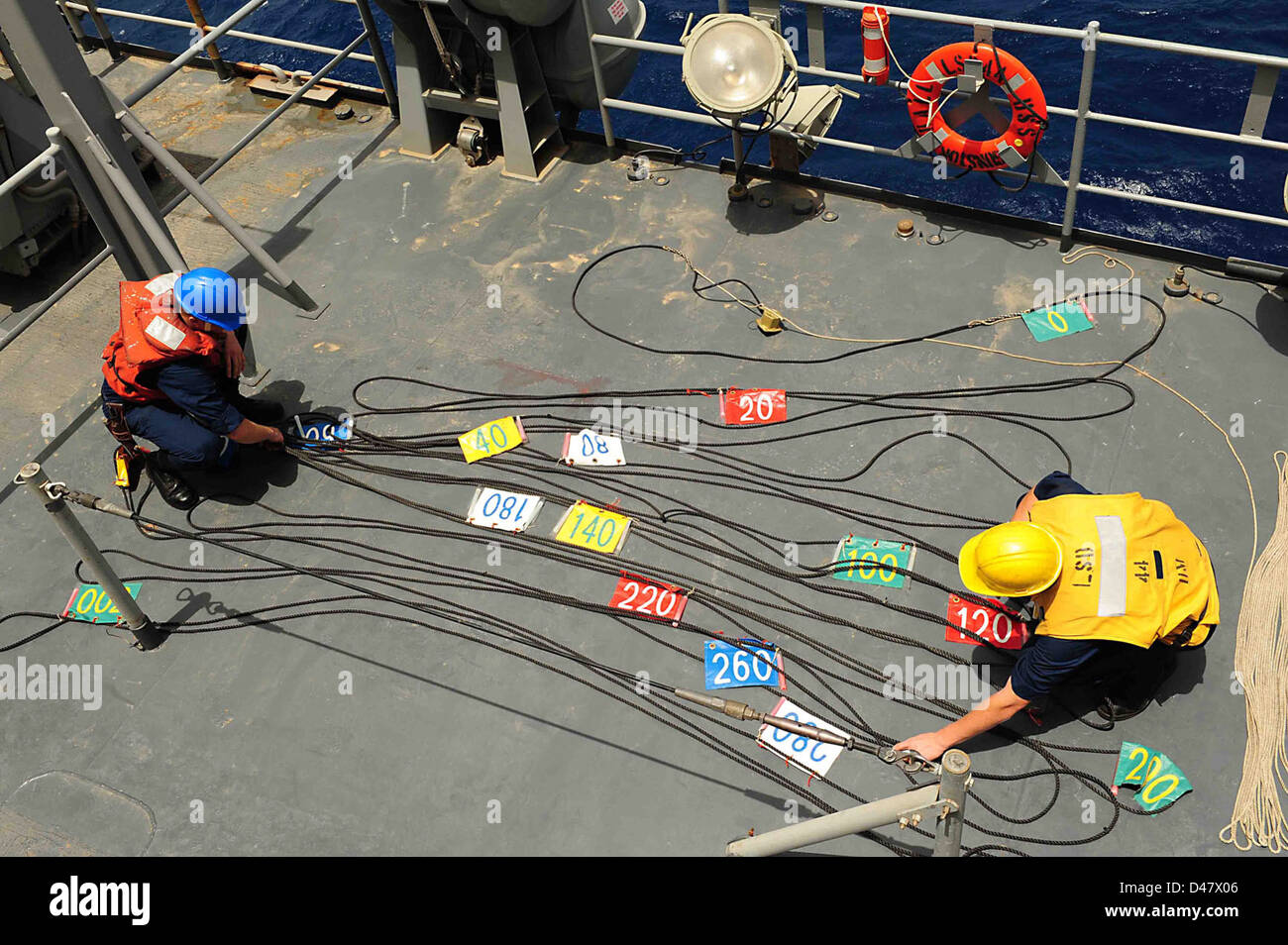 Sailors aboard a U.S. Navy vessel prepare phone and distance lines for ...