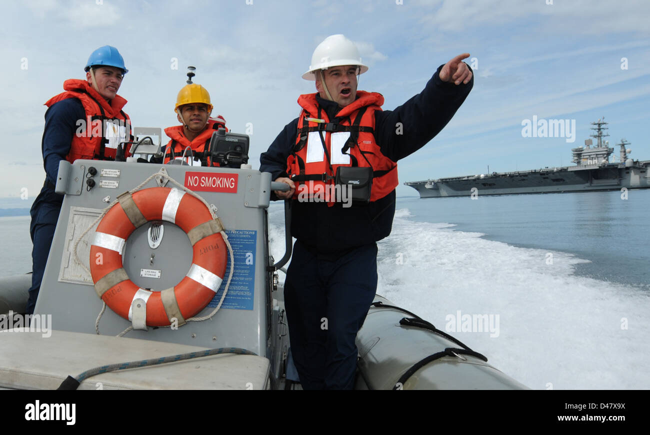 A Sailor points to a training dummy during a drill in the Pacific Ocean ...