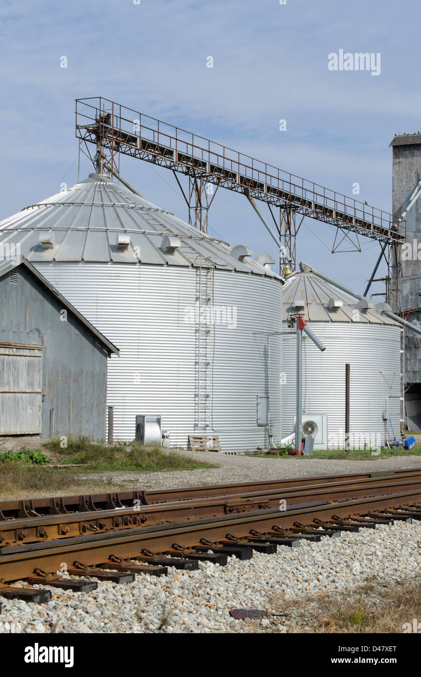 Grain storage silos of silver metal along the railroad tracks in rural ...