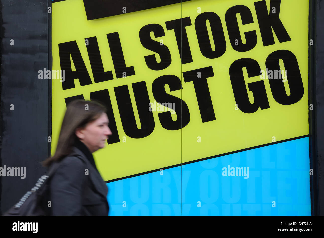 A shopper passes a sale sign in shop window Stock Photo - Alamy