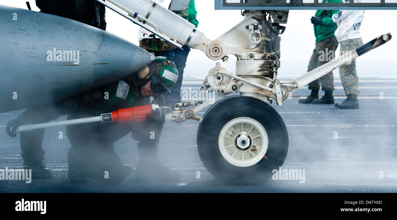 A Sailor aboard the USS John C. Stennis secures a hold back bar on a ...