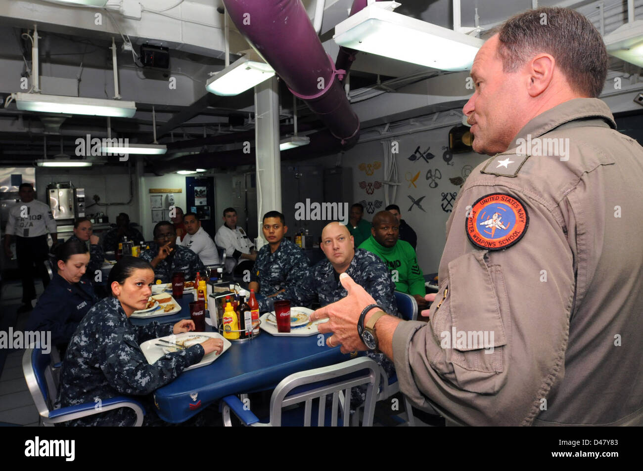 The commander of Carrier Strike Group 8 addresses personnel at the ...