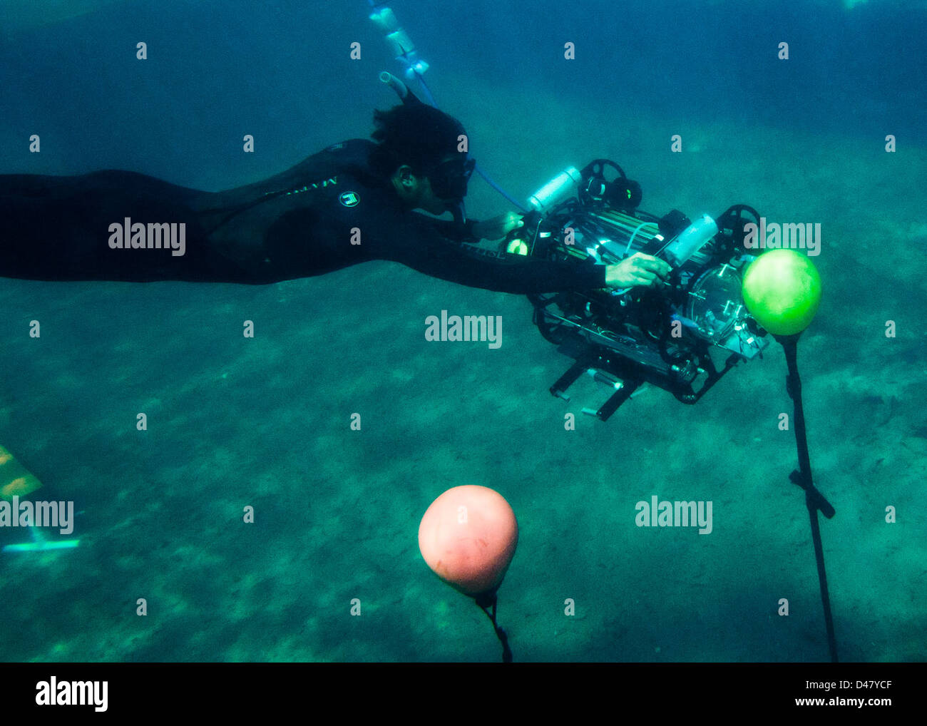 An engineer assists with an underwater robot during the NPASE West ...