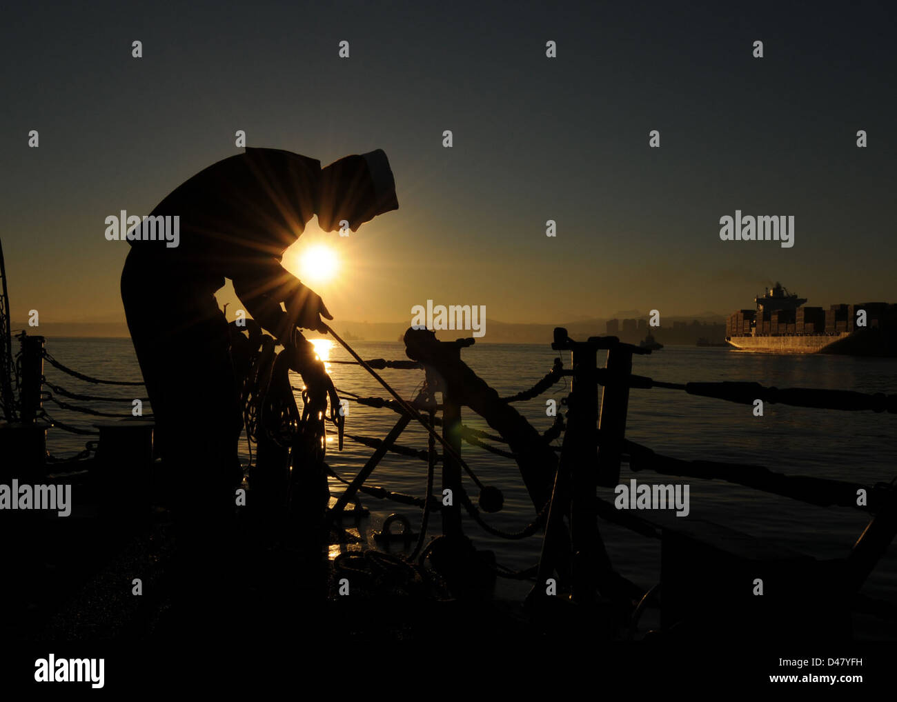 A Sailor aboard the USS Underwood prepares a heaving line, a critical ...