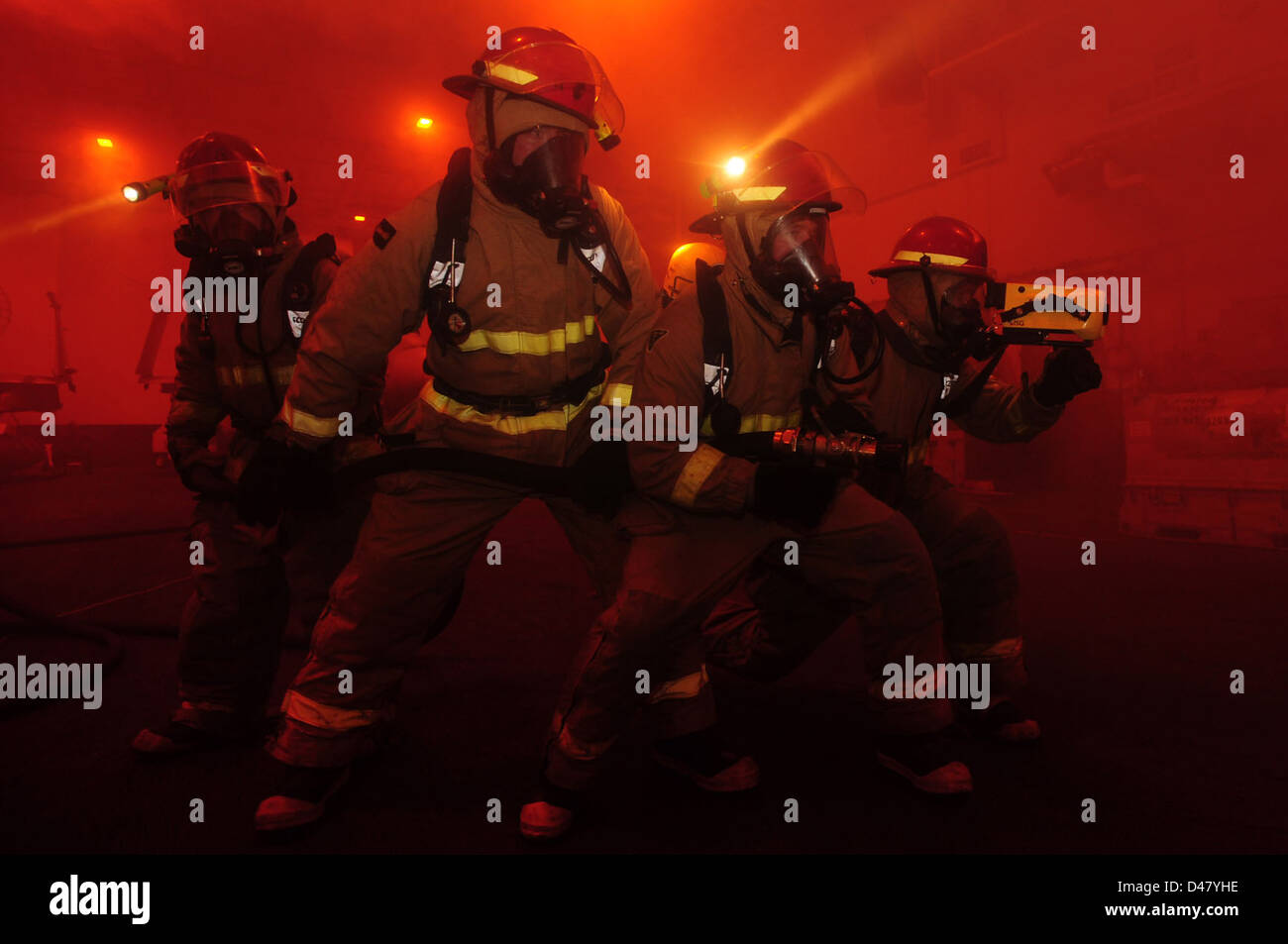 Sailors aboard a naval vessel practice firefighting techniques in the ...