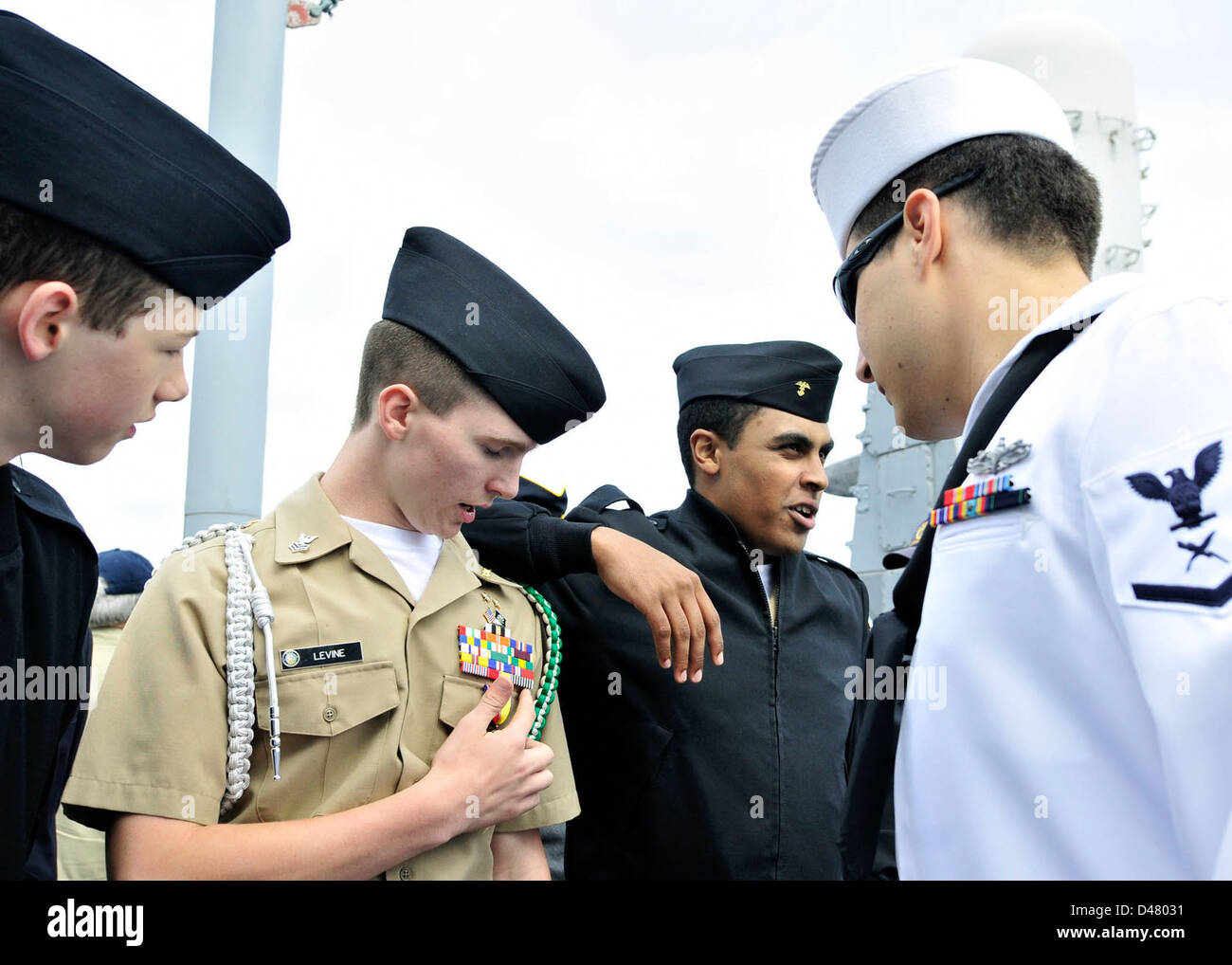 A U.S. Navy Sailor engages with Navy Junior ROTC cadets during an ...