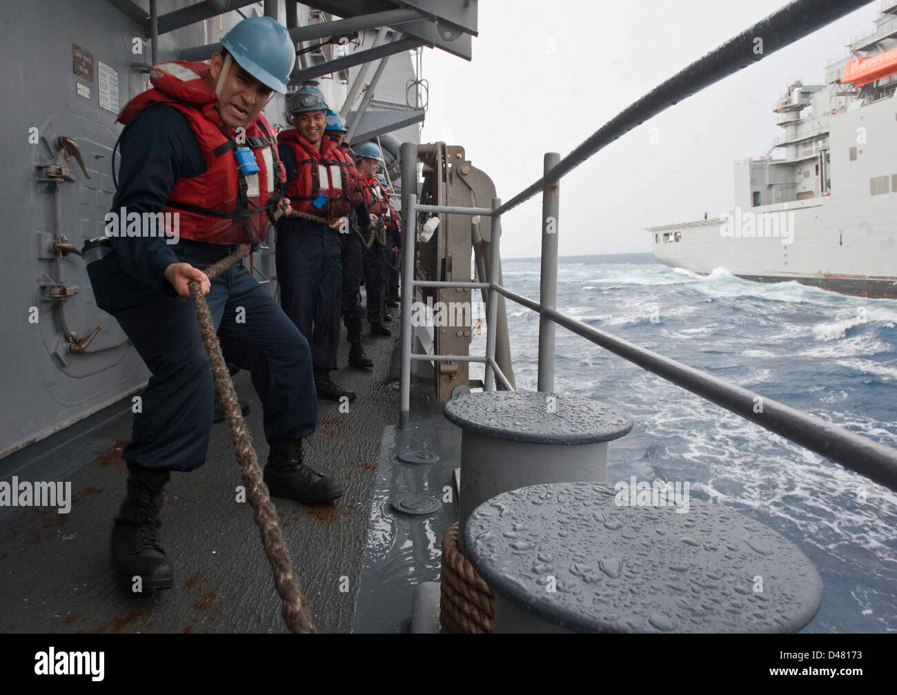 Sailors aboard a vessel in the Pacific Ocean perform line handling ...