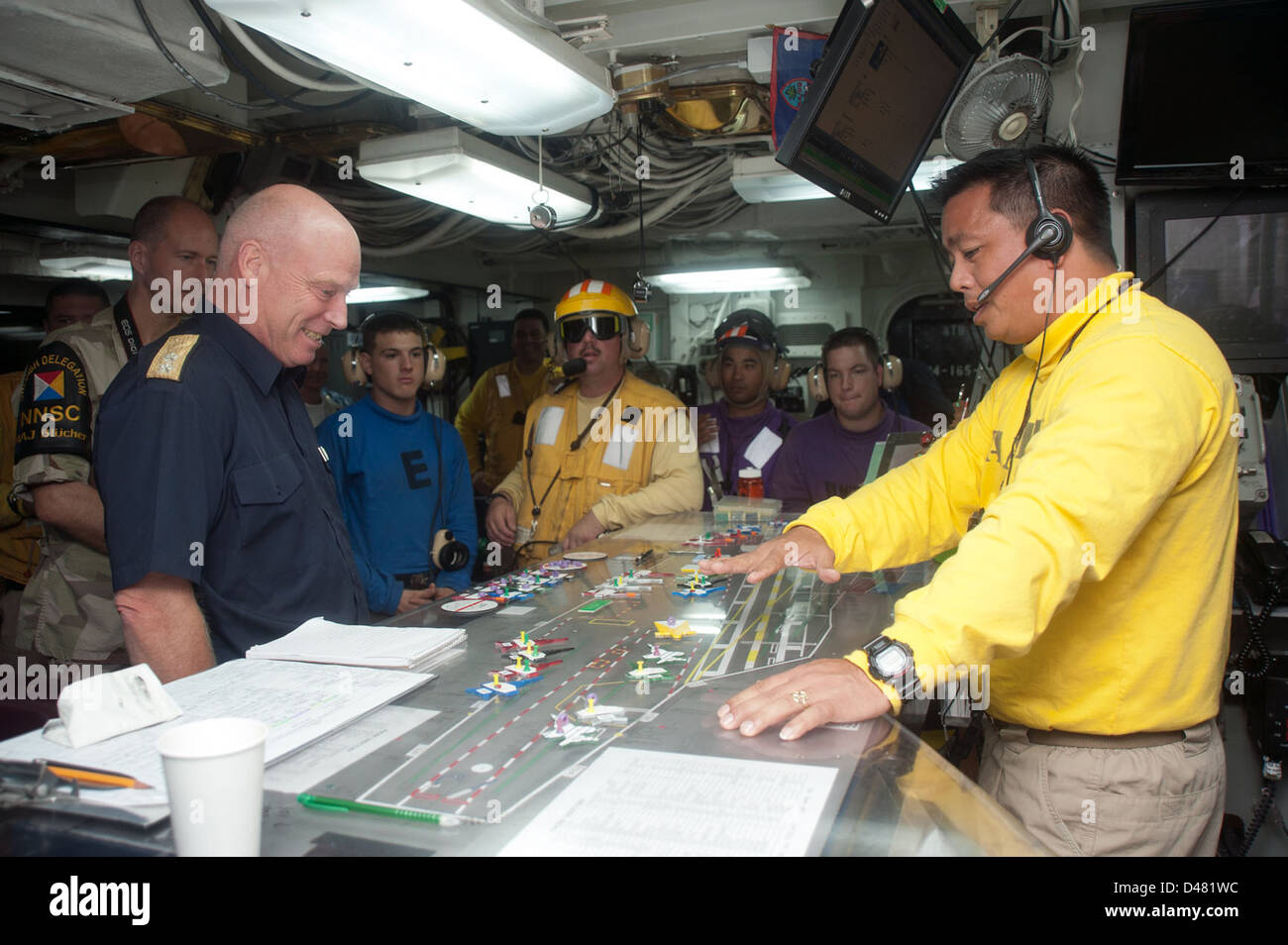 A Navy officer provides an explanation of flight operations aboard the ...