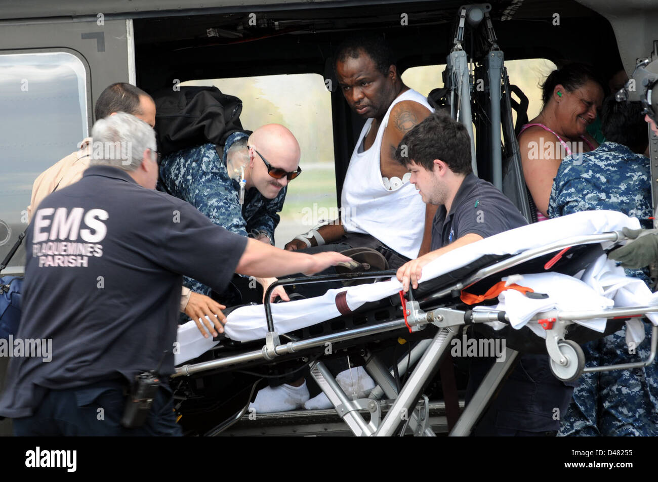 Emergency Management Services personnel assist a man from a UH-60 Black ...