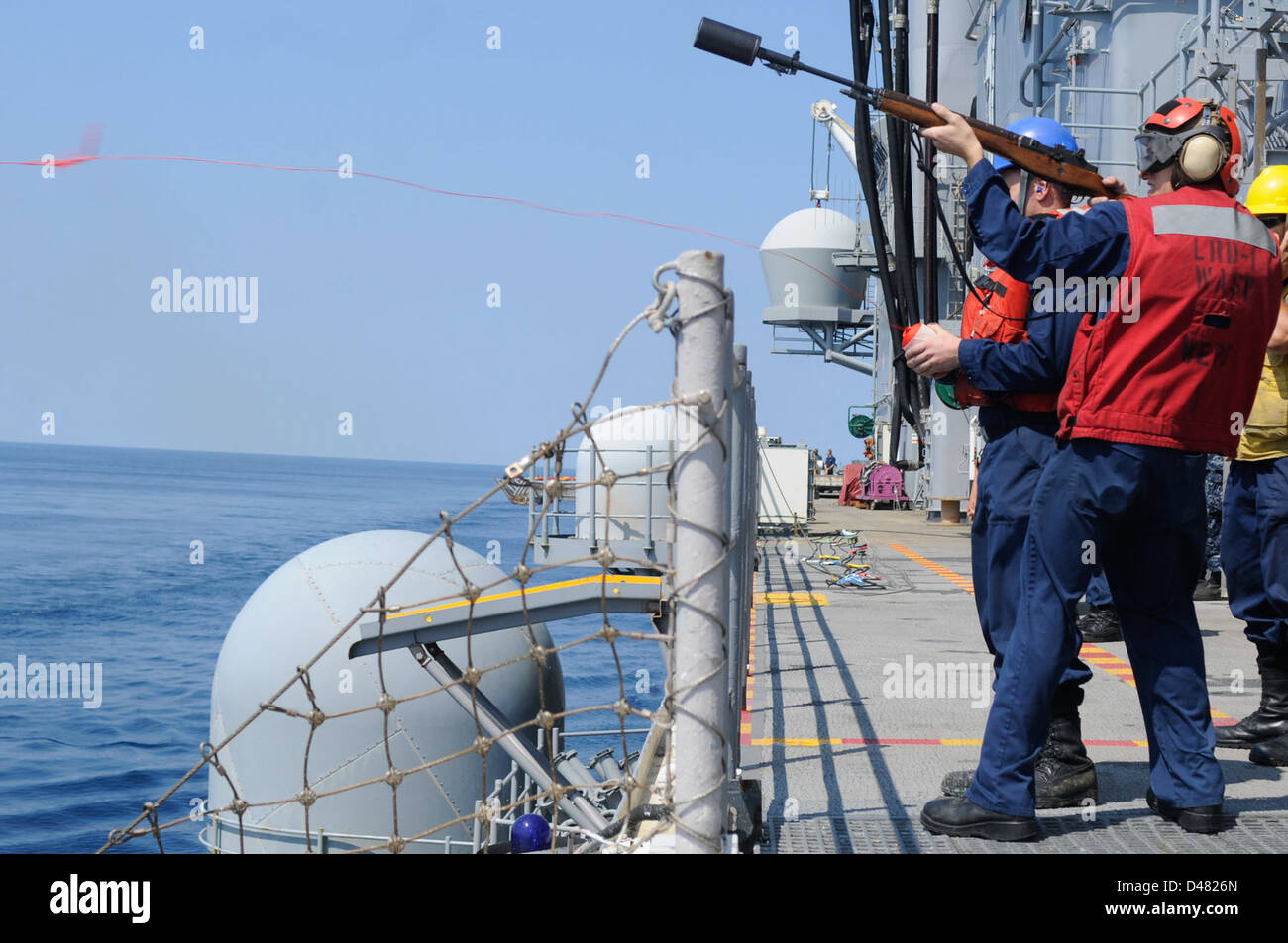 A U.S. Navy sailor fires a messenger line during routine operations ...