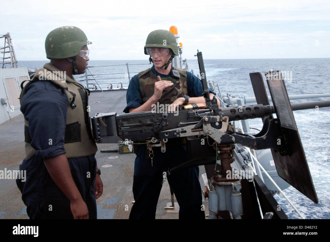 A U.S. Navy Sailor instructs an officer on the proper operation of the ...