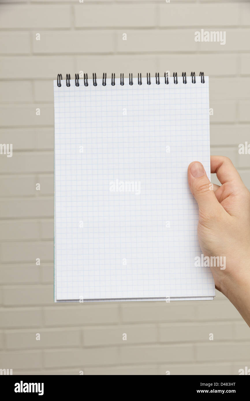 female teen hand holding notepad, against brick wall Stock Photo - Alamy