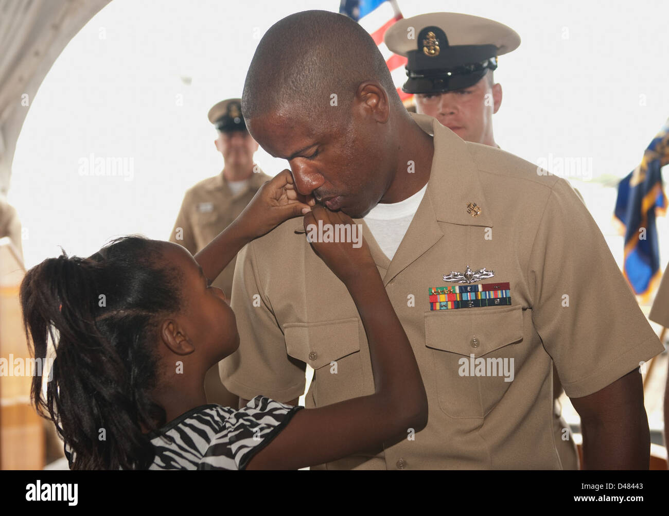 A U.S. Navy chief is pinned by his daughter during a promotion ceremony ...